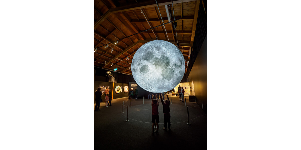 Kids beholding a giant model of the moon at the Museum